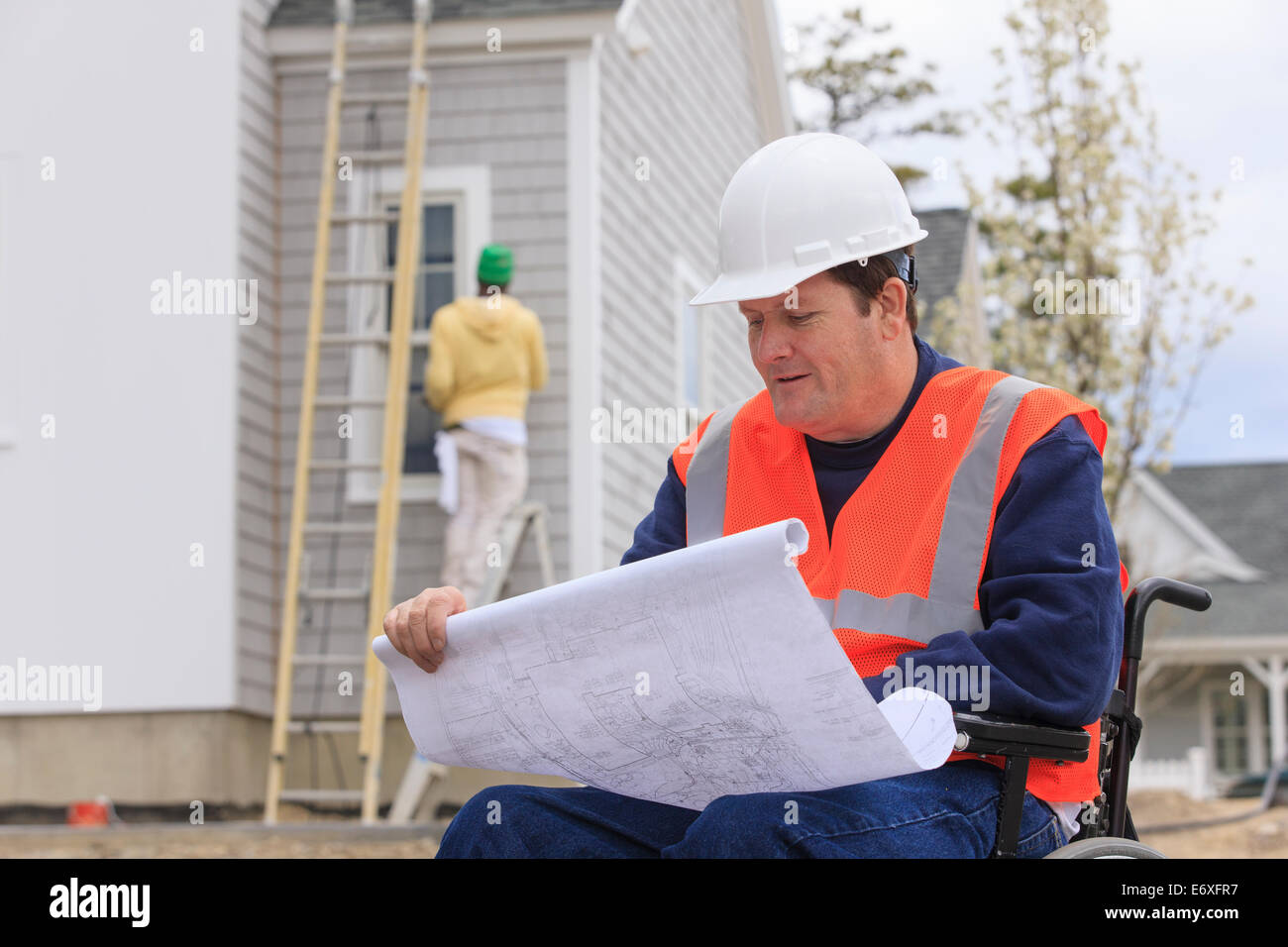 Construction engineer with spinal cord injury with house plans at ...