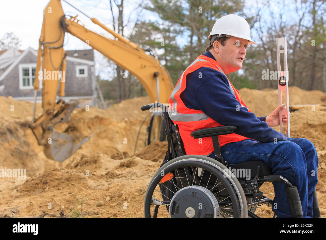 Construction engineer with spinal cord injury holding level at site ...