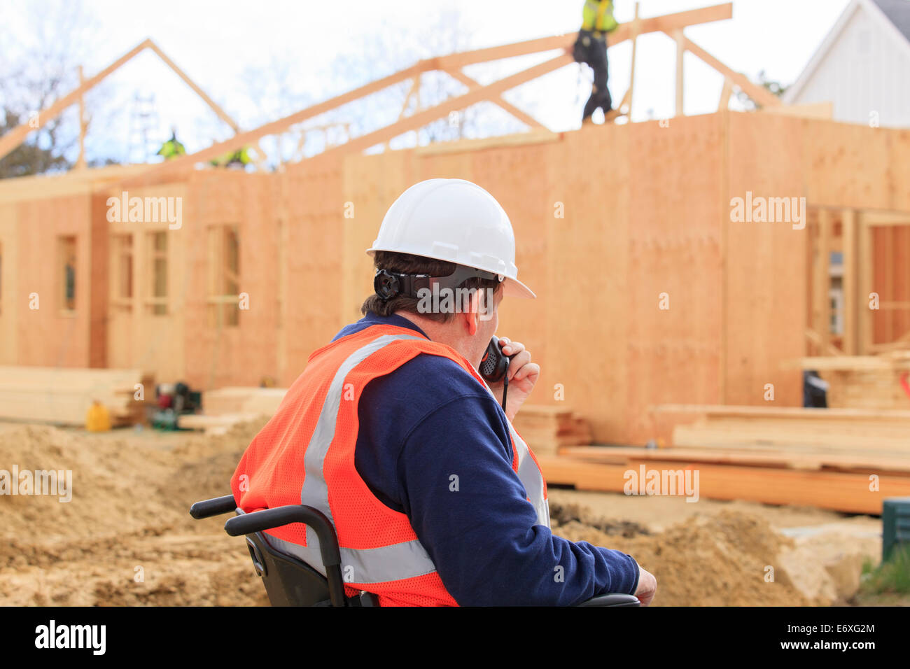 Construction engineer with spinal cord injury talking on radio at home ...