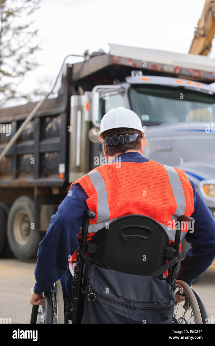 Construction engineer with spinal cord injury watching dump truck ...