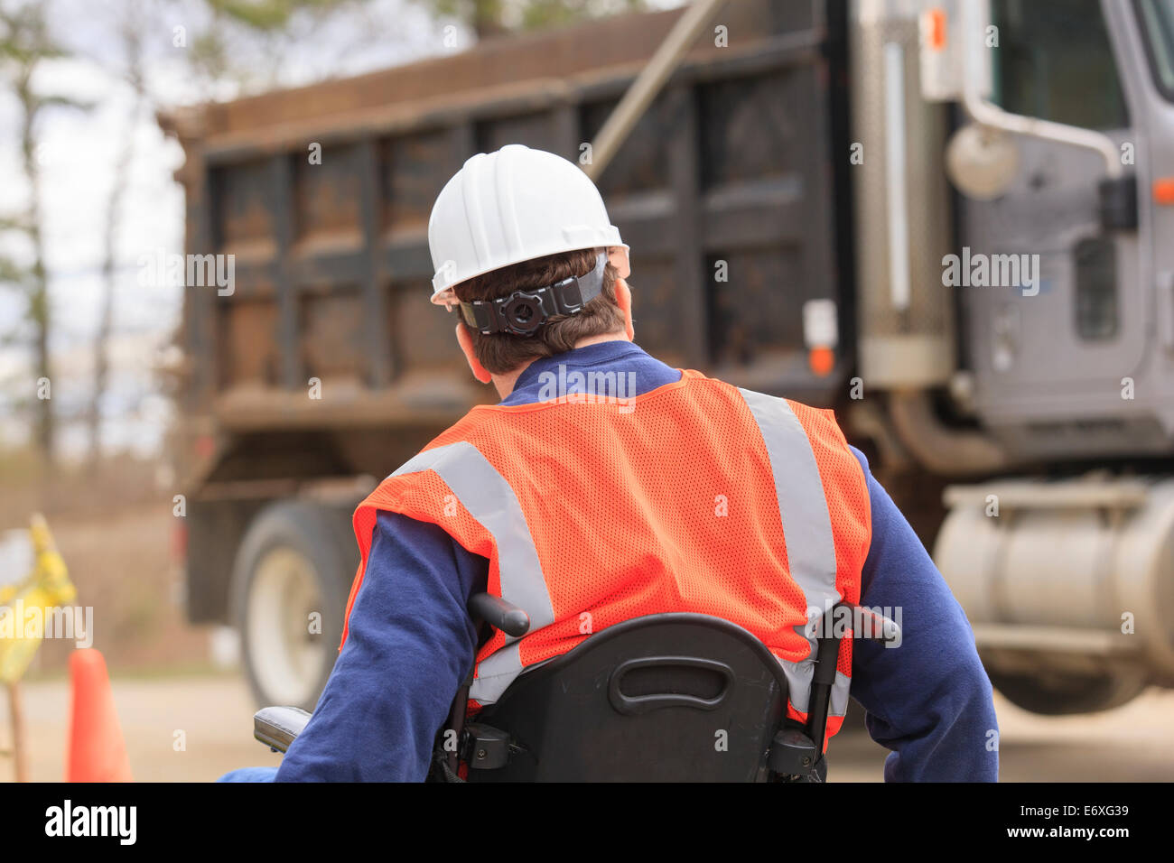 Construction engineer with spinal cord injury watching equipment ...
