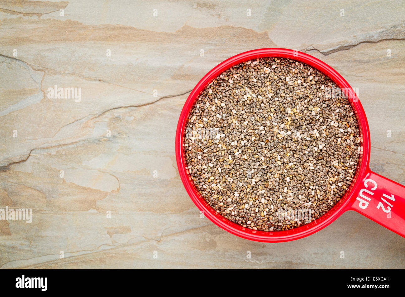 chia seeds in a red measuring cup against slate rock background, top ...