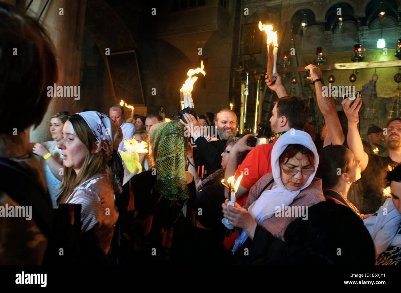 Elderly priest holds candles with fire in Church of the Holy Sepulchre ...