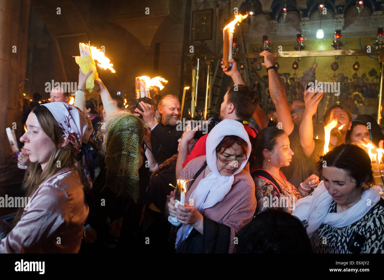 Elderly priest holds candles with fire in Church of the Holy Sepulchre ...