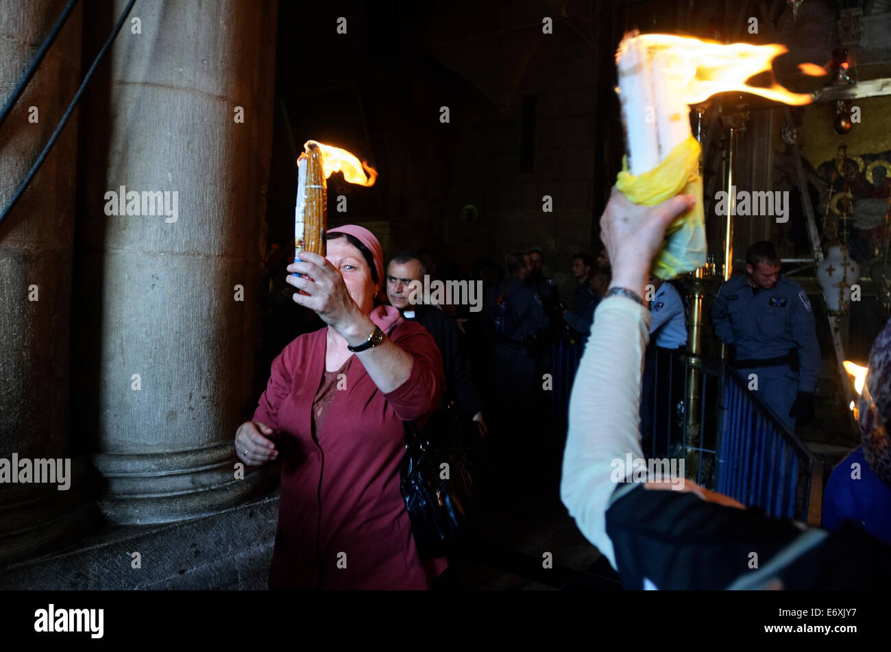 Woman carries candle with Holy Fire out the Church of the Holy ...