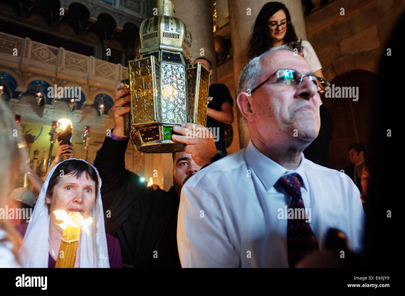 People hold candles with fire in Church of the Holy Sepulchre during ...