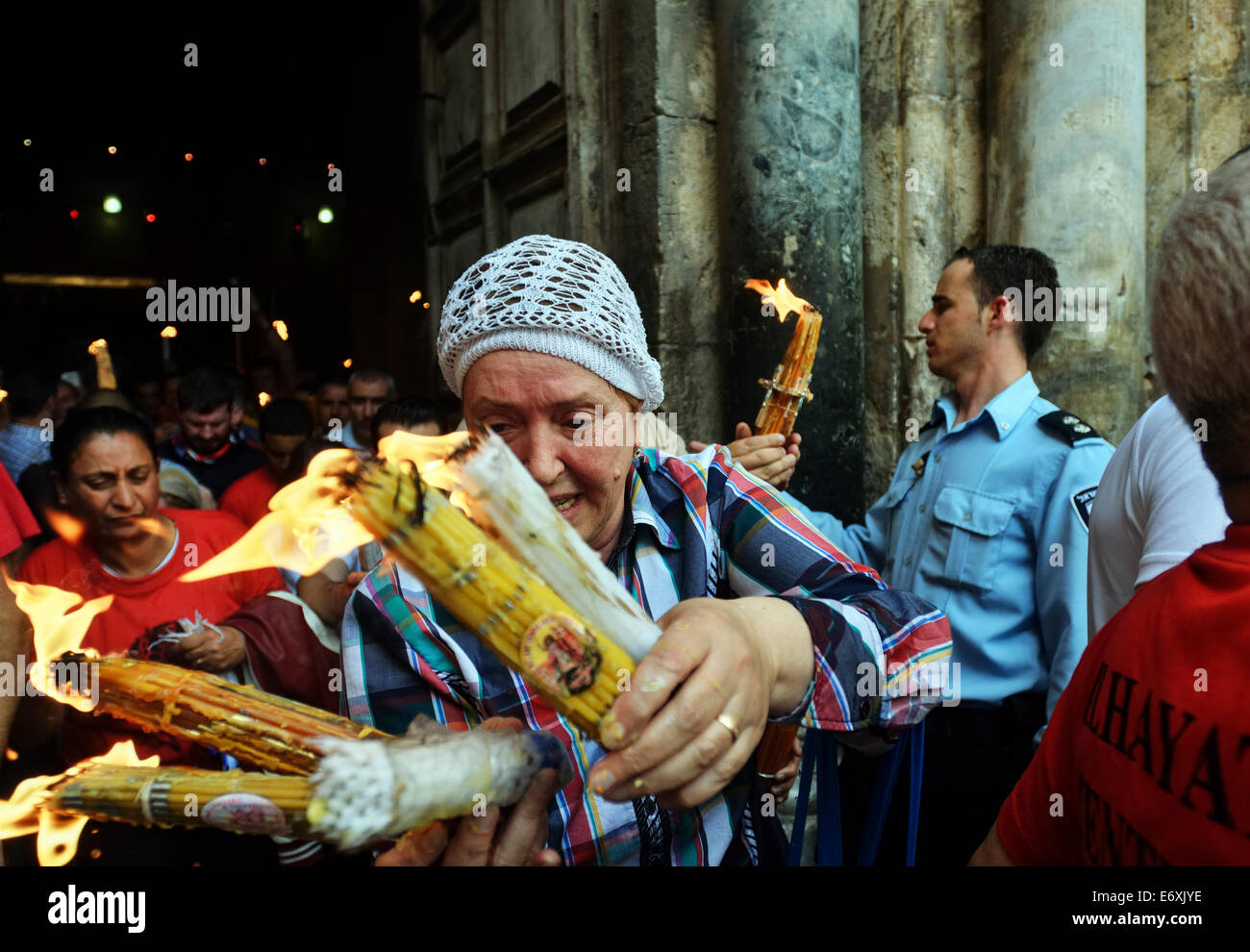 Woman carries candle with Holy Fire out the Church of the Holy ...