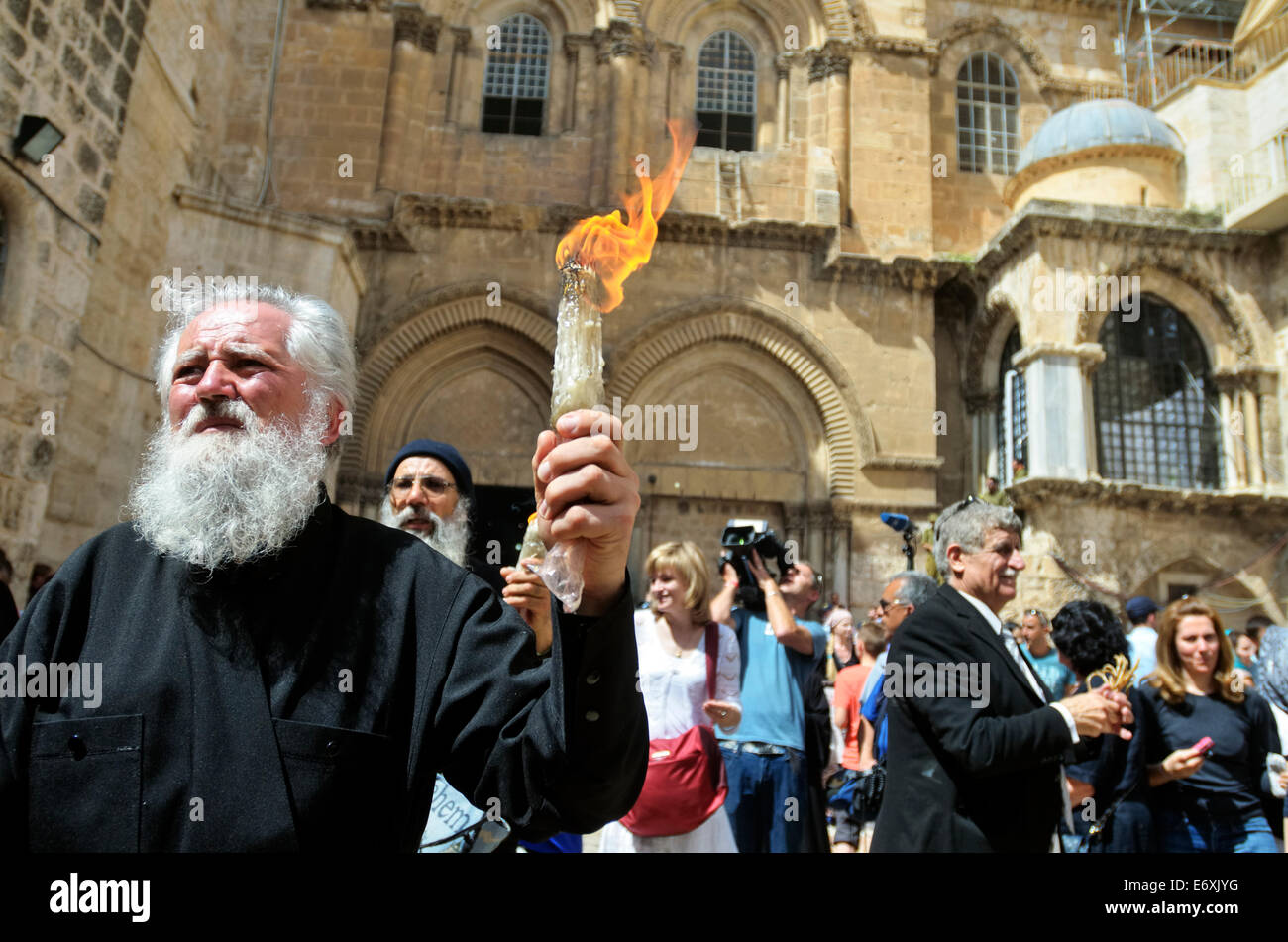 Elderly priest holds candles with fire in Church of the Holy Sepulchre ...