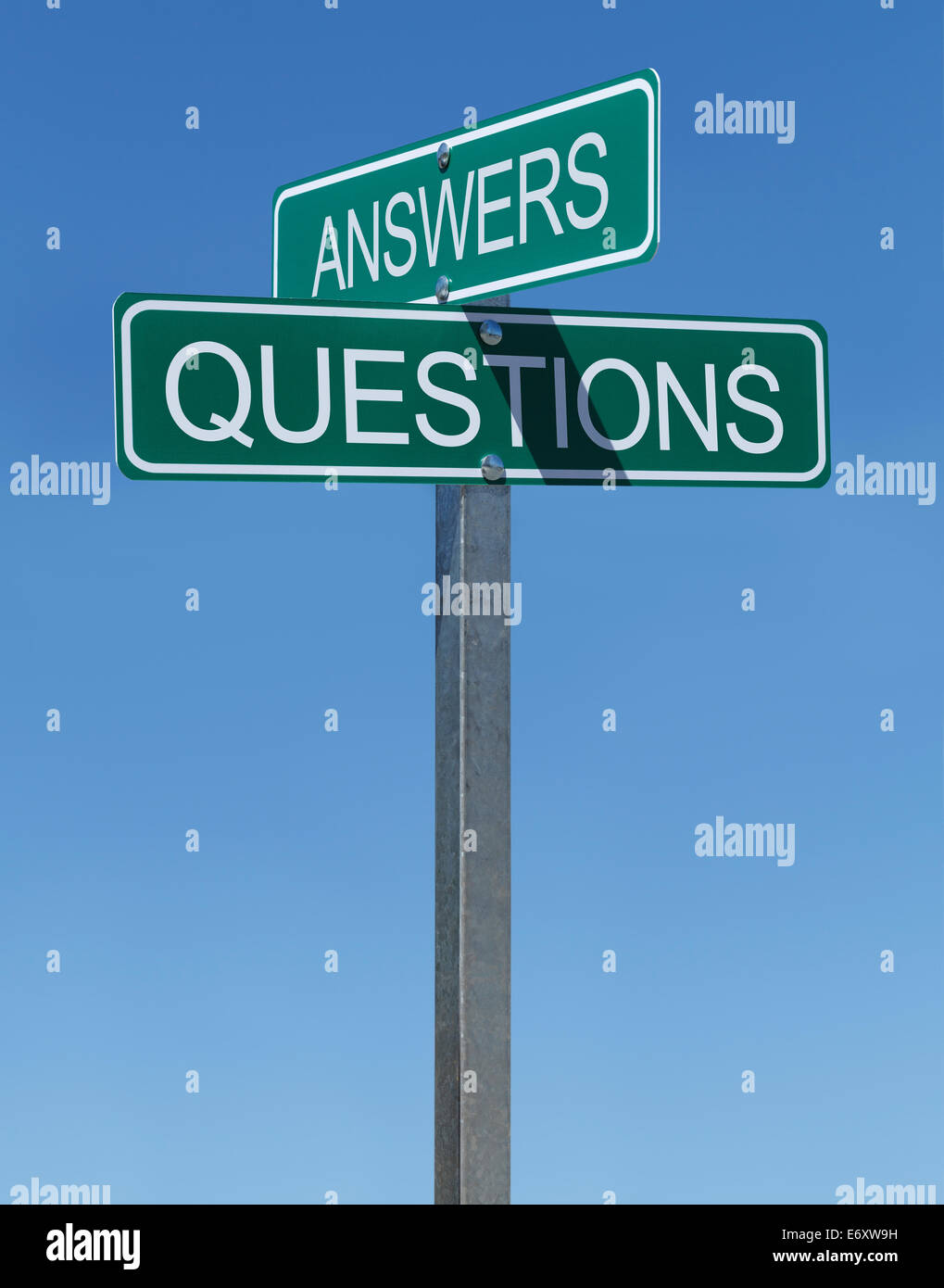 Two Green Street Signs Answers Questions on Metal Pole With Blue Sky ...