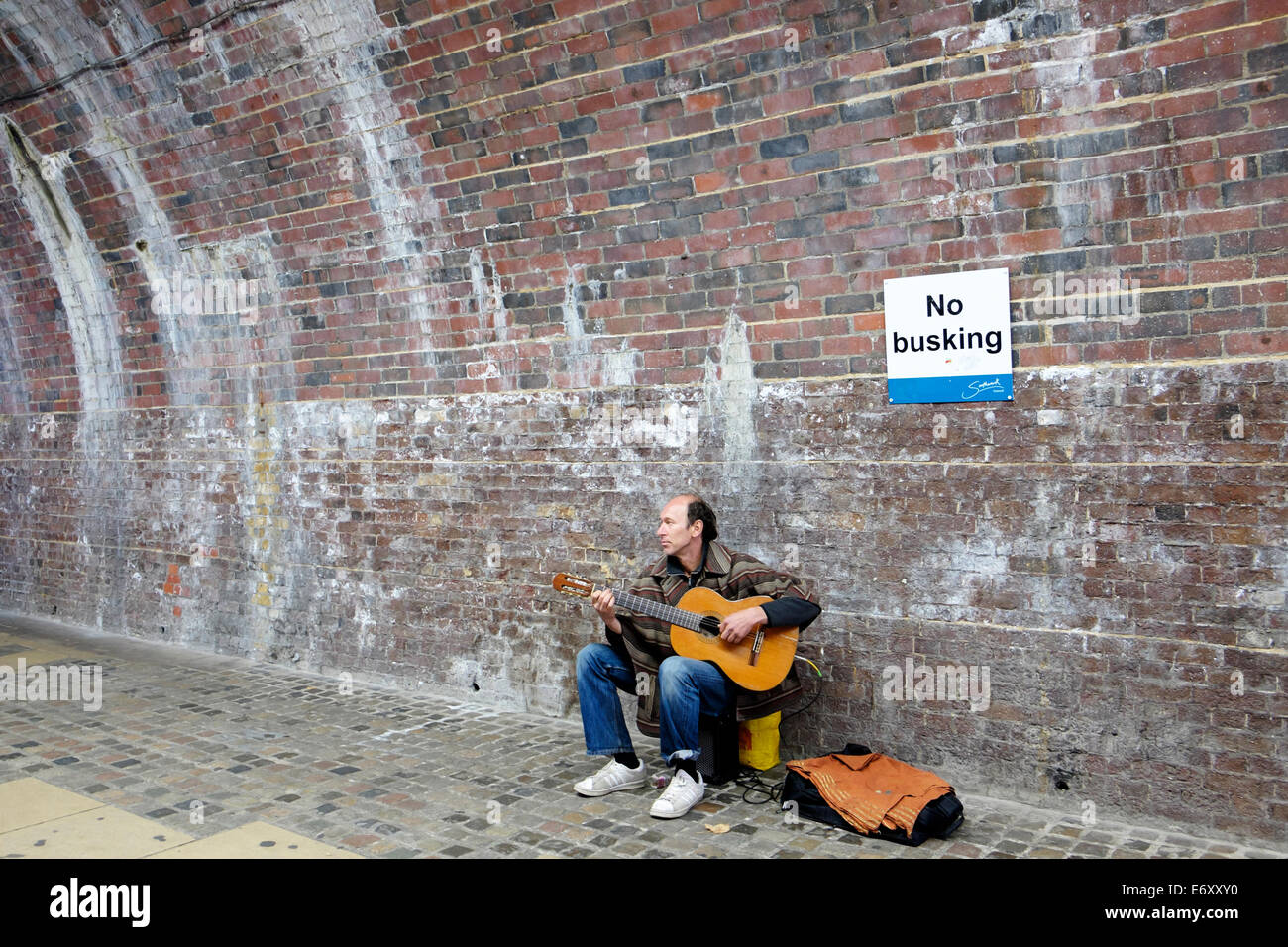 Male busker sitting playing guitar hi-res stock photography and images ...