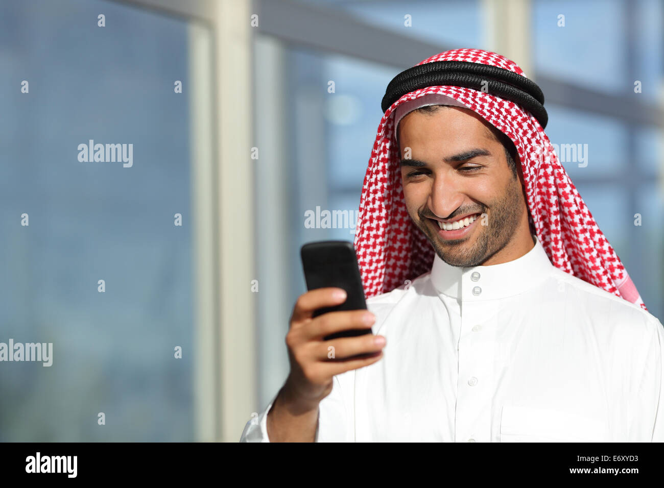 Arab saudi businessman working with his phone with an office building ...