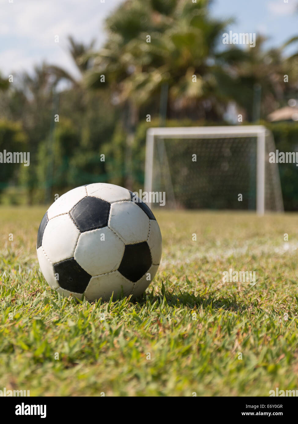 black and white soccer ball in grass on outdoor green field near five-a ...