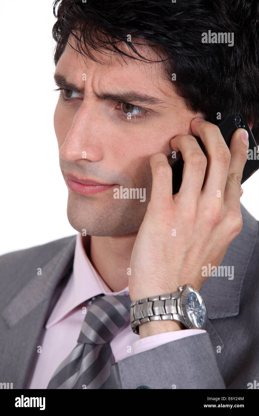 Frowning businessman using a cellphone Stock Photo - Alamy