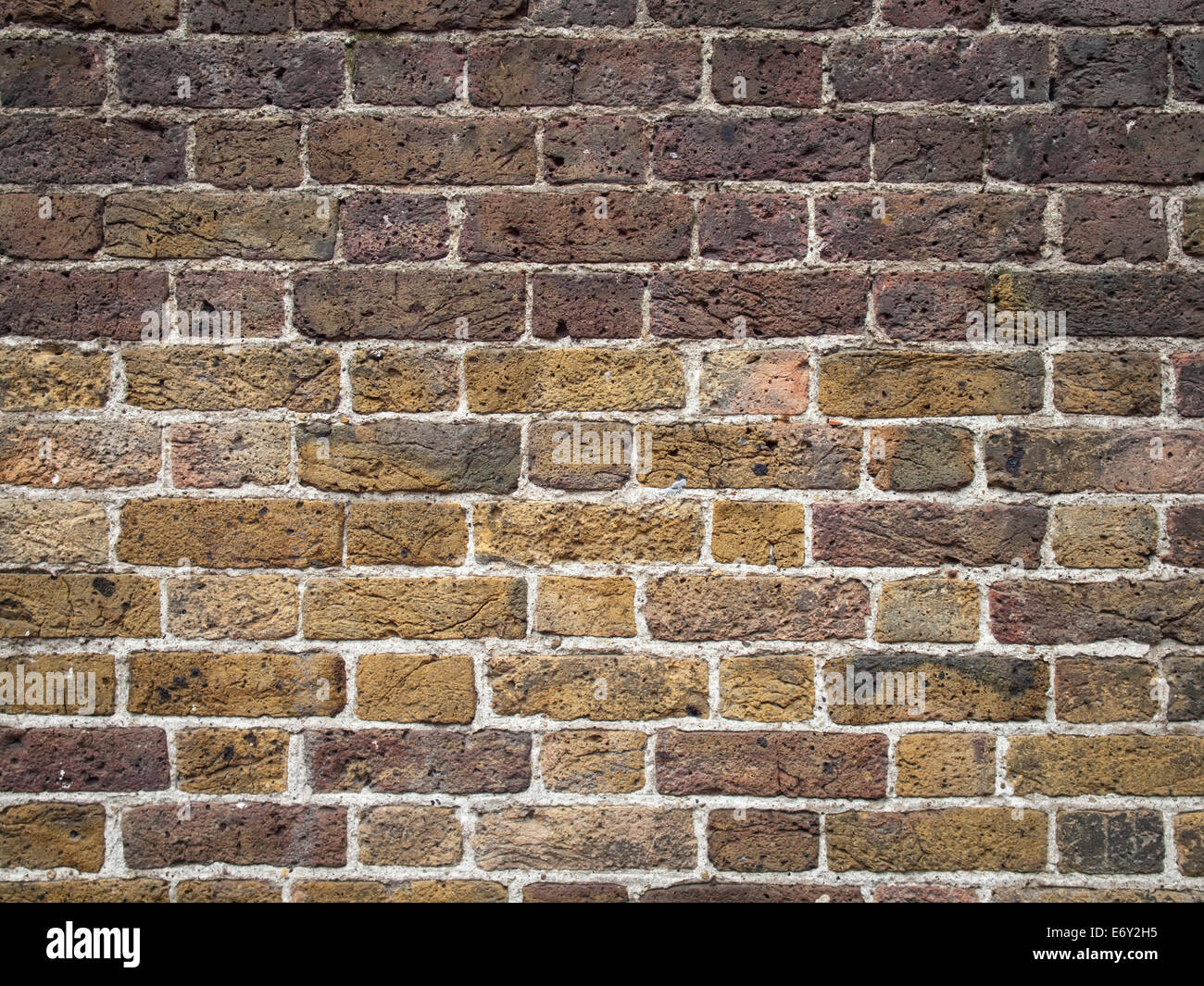 detail of a brick wall with red and yellow bricks and white mortar ...