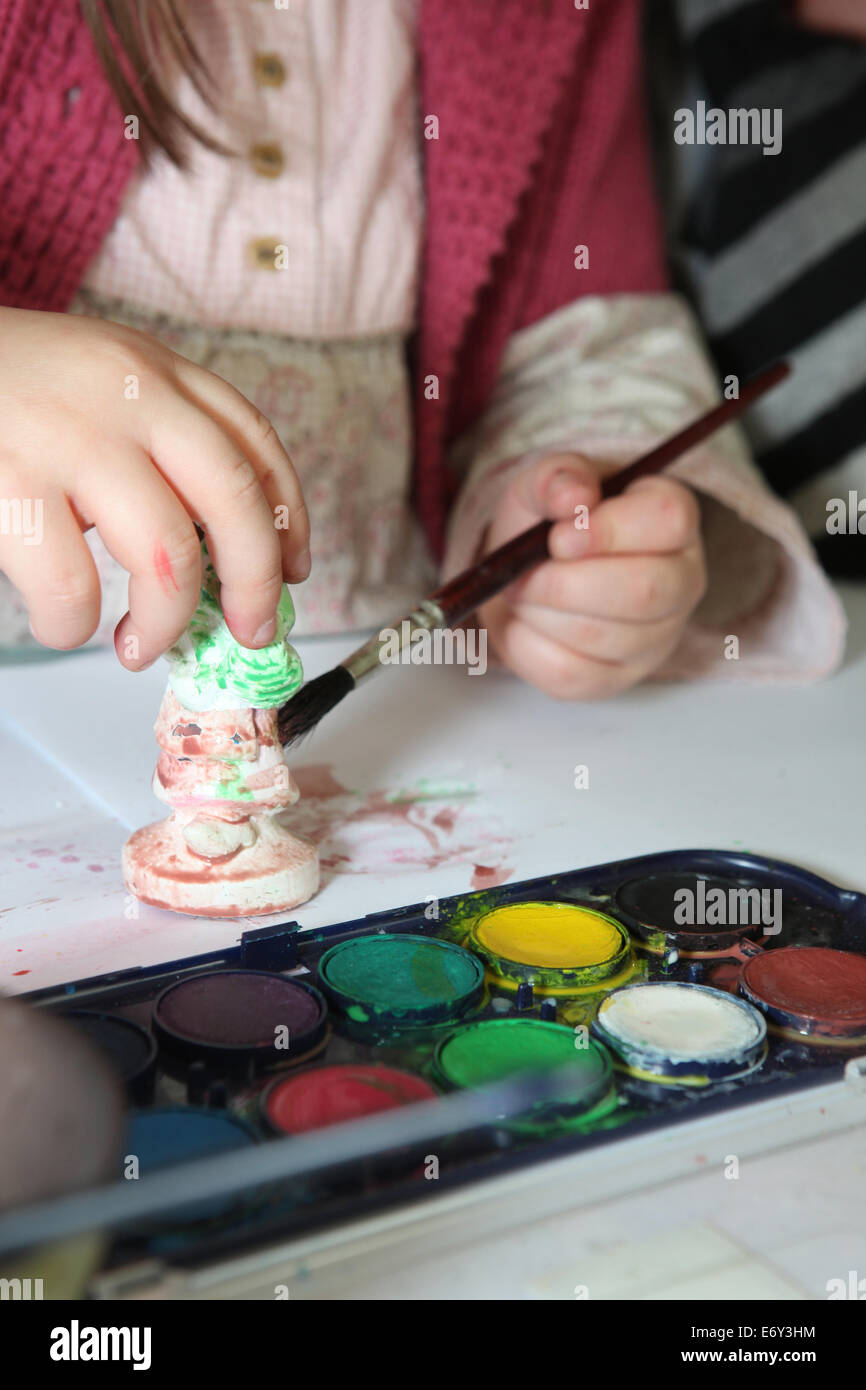 Child painting a plaster figurine Stock Photo - Alamy