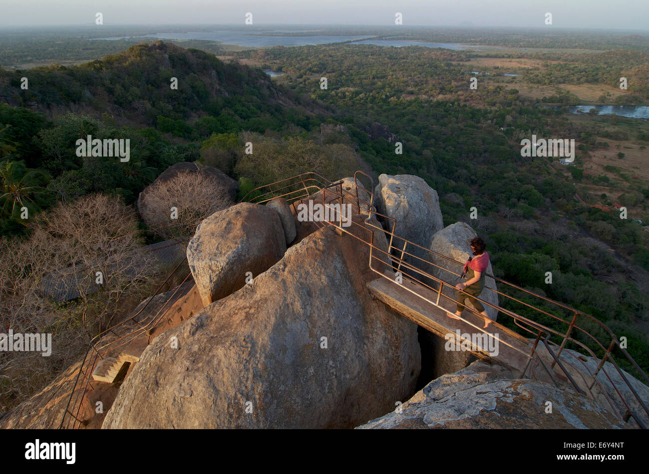 Female tourist walking on top of the Aradhana Gala Rocks on Mihintale ...