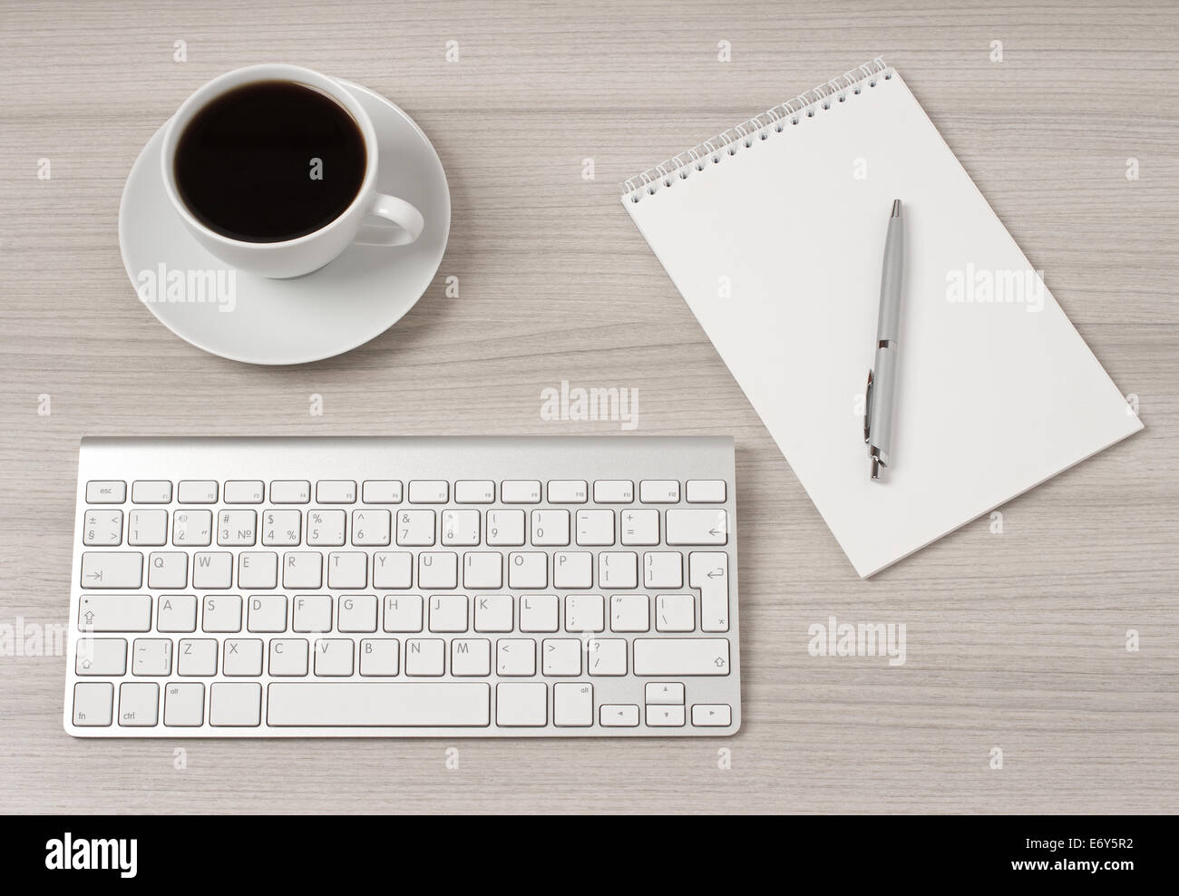 Computer desk with a cup of coffee, a notebook and pen Stock Photo - Alamy