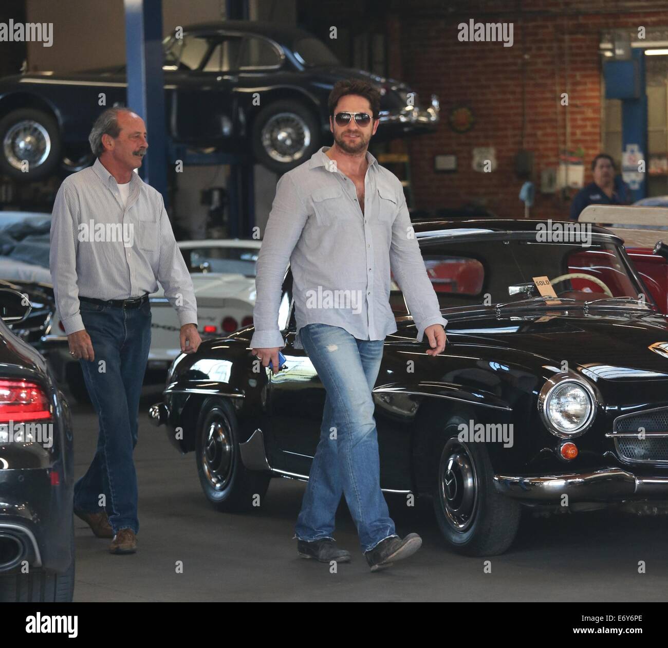 Gerard Butler looks at classic antique automobiles at Heritage Classic ...