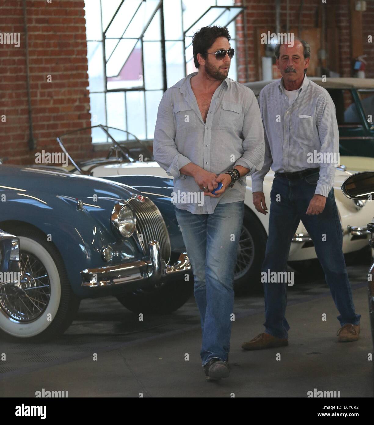 Gerard Butler looks at classic antique automobiles at Heritage Classic ...