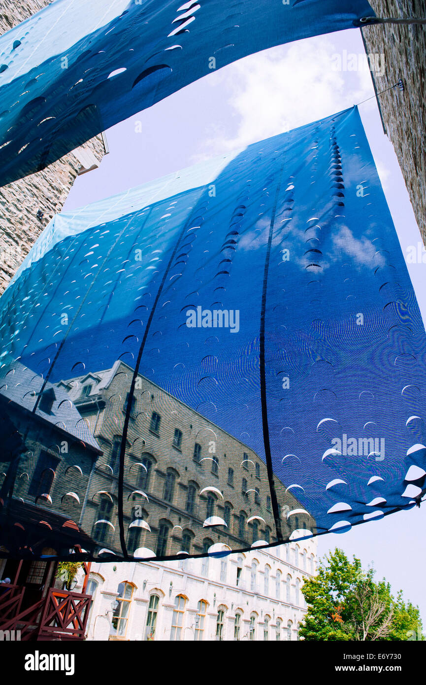 massive blue flags hanging in between two old buildings in old Québec ...