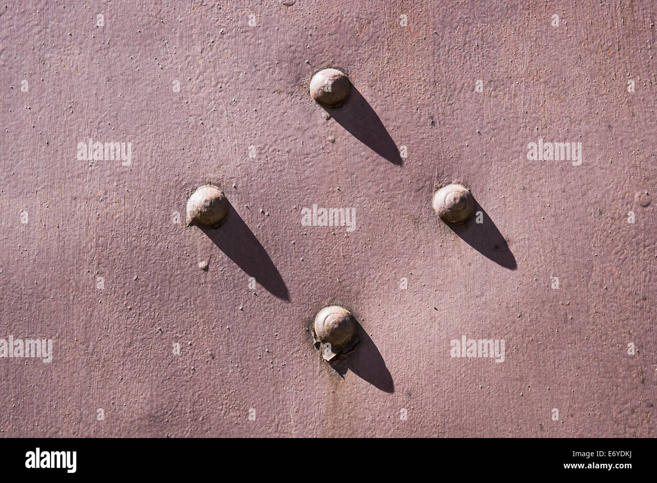 Four old rivets. Closeup view of the ancient metal plate with four ...
