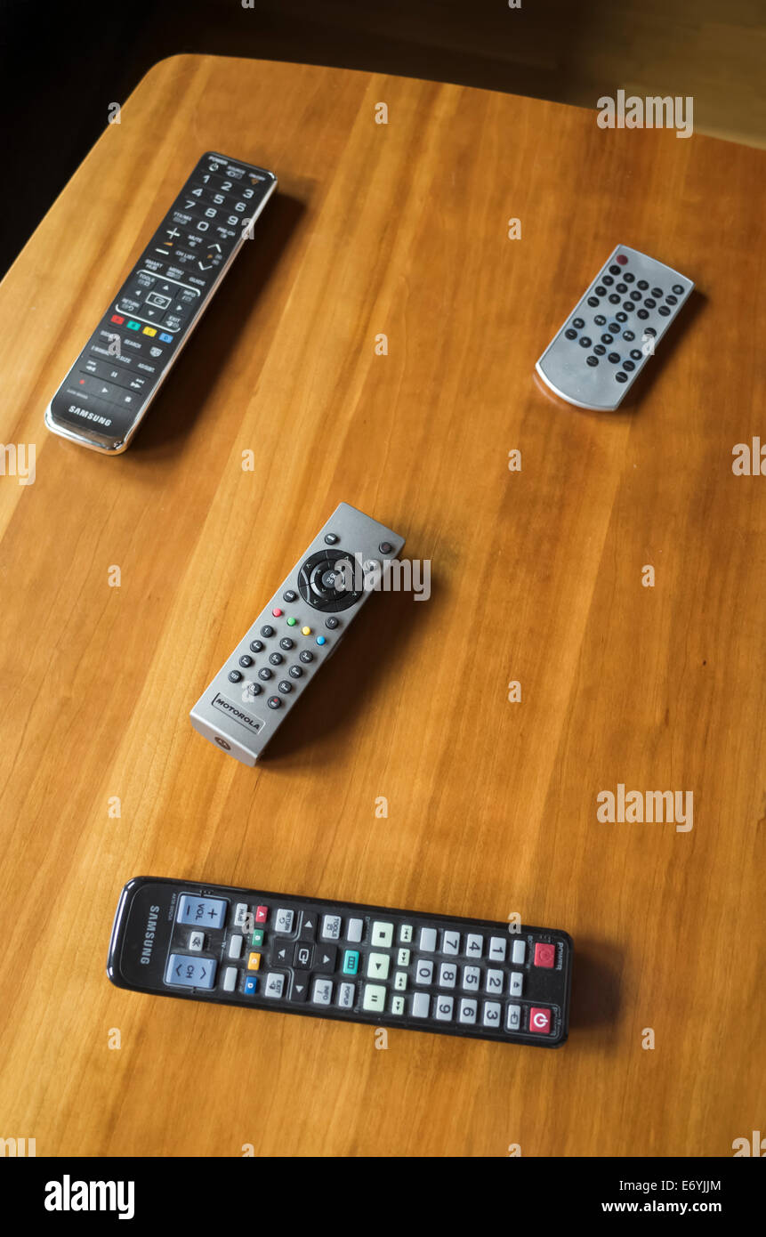 Four remote controls on a wooden table. FOR EDITORIAL USE ONLY Stock ...