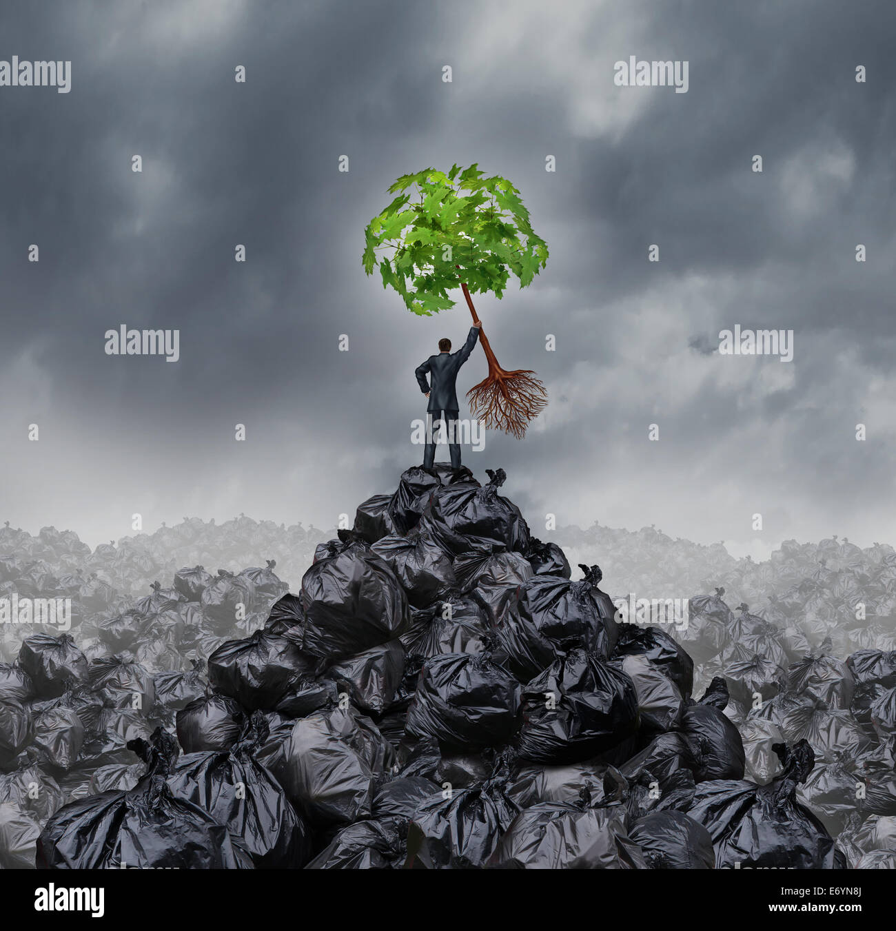 Green businessman concept as a man on top of a mountain heap of garbage ...