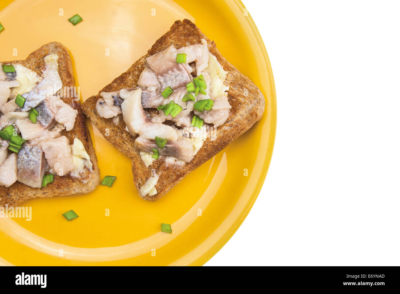 Two toast with salted herring on yellow plate, isolated Stock Photo - Alamy
