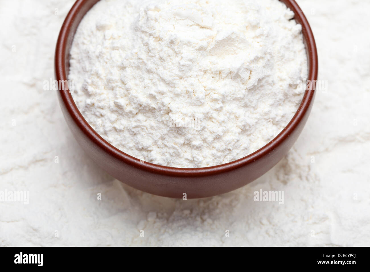 Flour in bowl on flour background. Closeup Stock Photo - Alamy