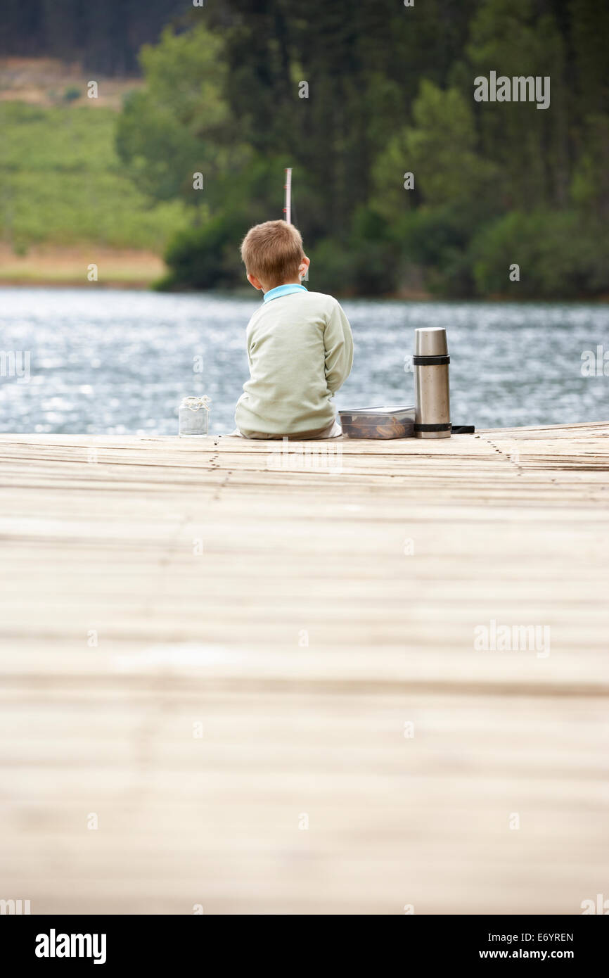 Young boy fishing on a jetty Stock Photo - Alamy