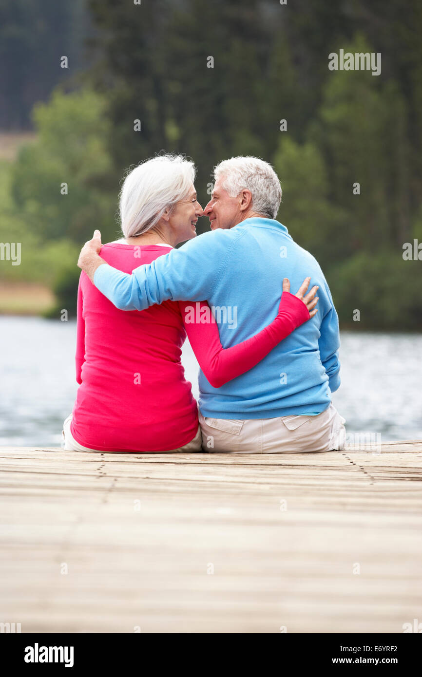 Romantic senior couple sitting on a jetty Stock Photo - Alamy