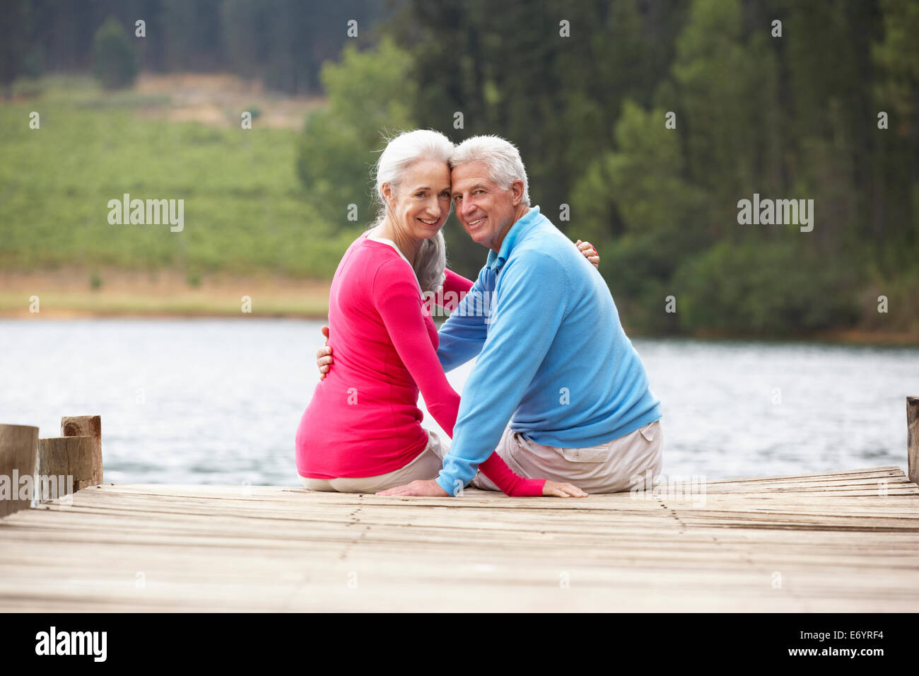 Romantic senior couple sitting on a jetty Stock Photo - Alamy