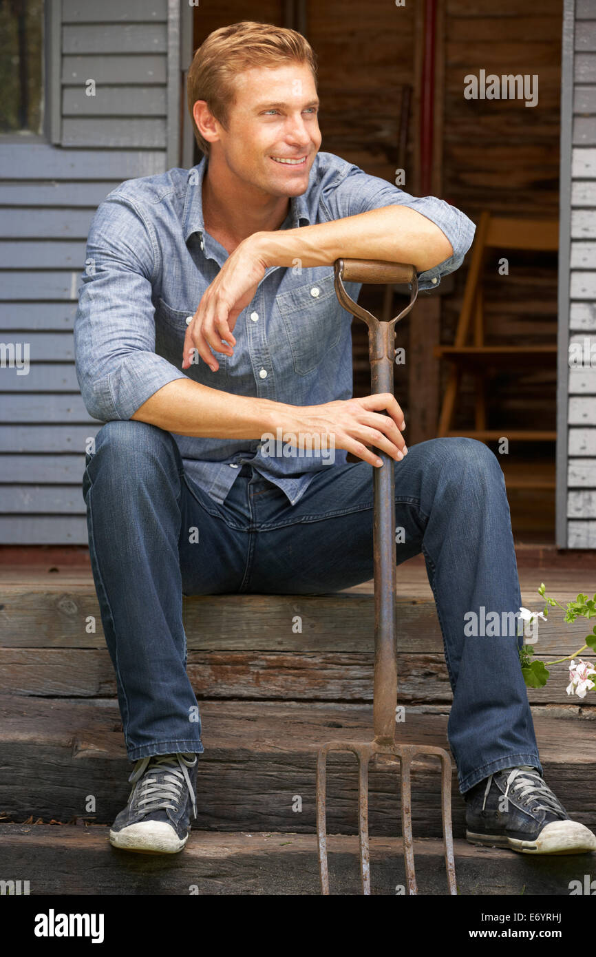 Man leaning on garden fork Stock Photo - Alamy