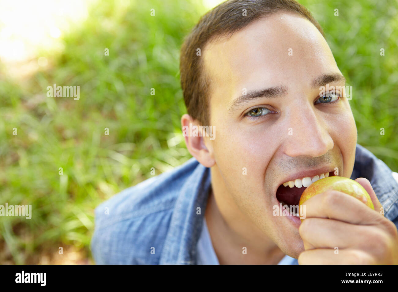 Man eating apple outdoors Stock Photo - Alamy