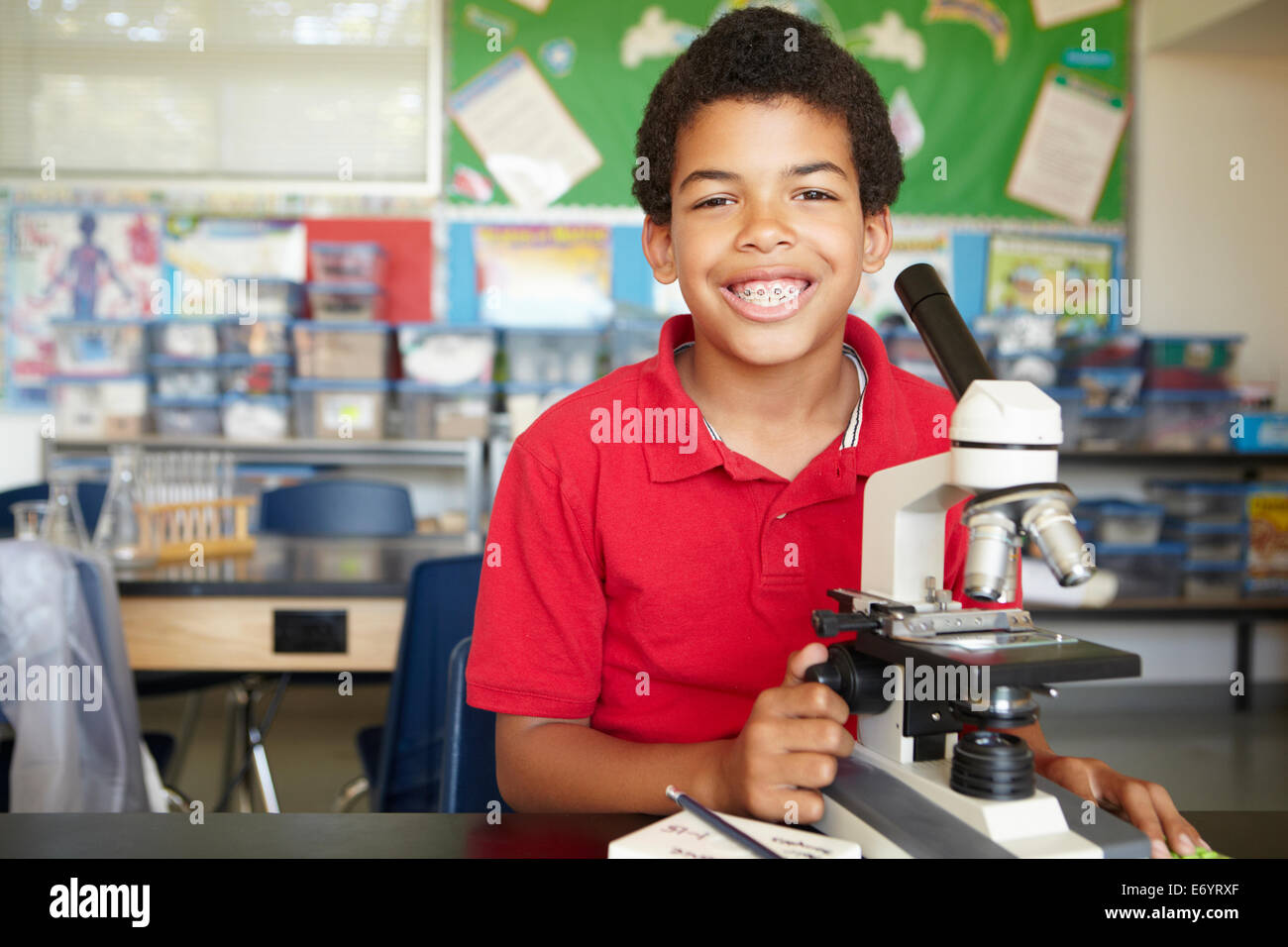 Boy in science class with microscope Stock Photo - Alamy