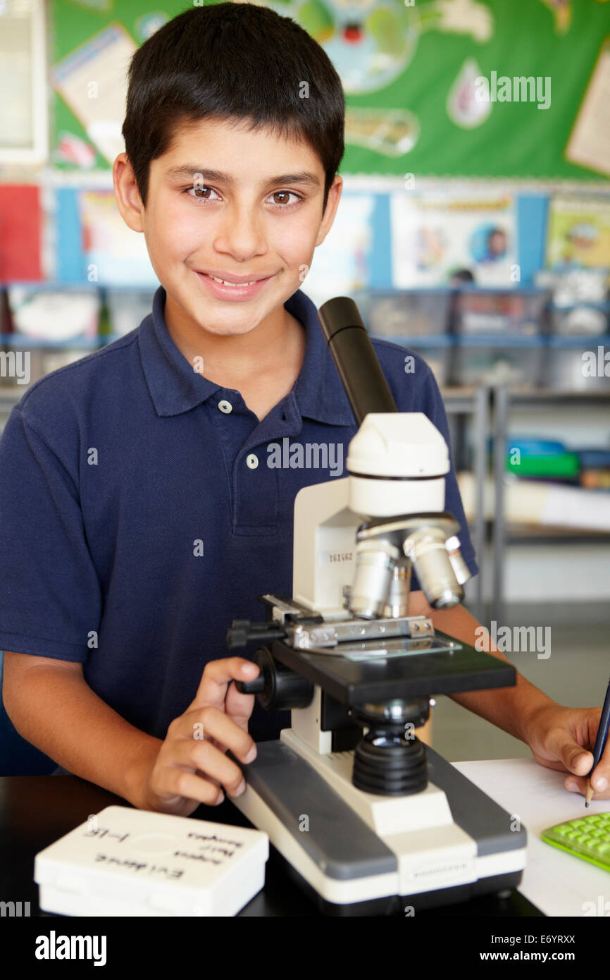 Boy in science class with microscope Stock Photo - Alamy