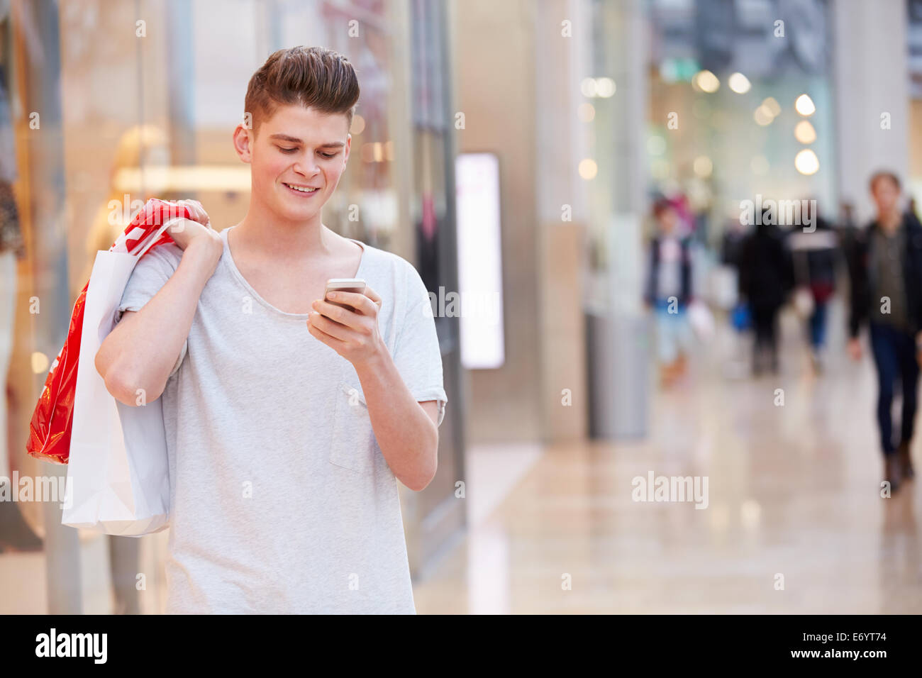 Man In Shopping Mall Using Mobile Phone Stock Photo - Alamy