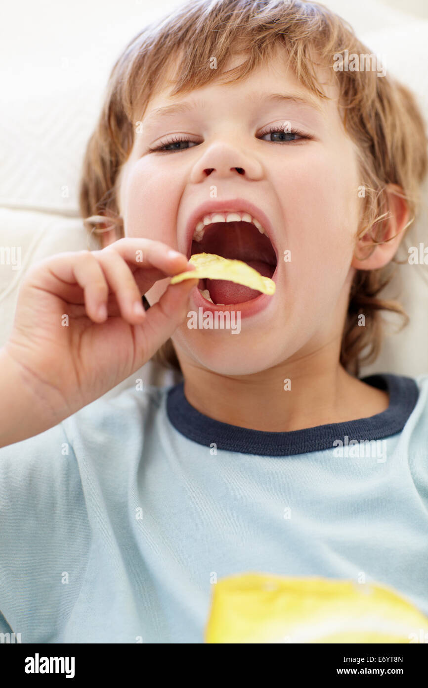 Young boy eating crisps Stock Photo - Alamy