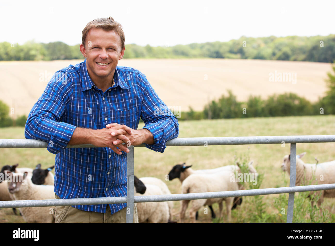 Man leaning on country fence Stock Photo - Alamy