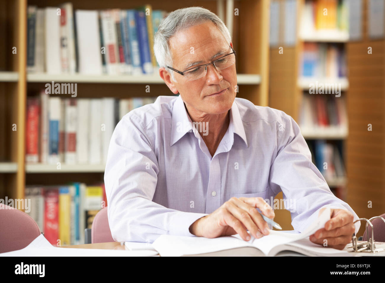 Senior student working in library Stock Photo - Alamy