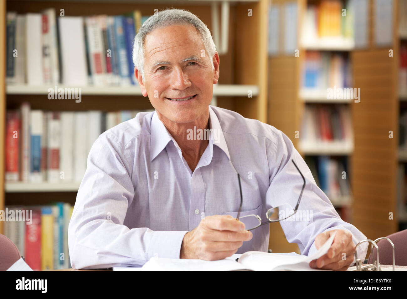Senior student working in library Stock Photo - Alamy