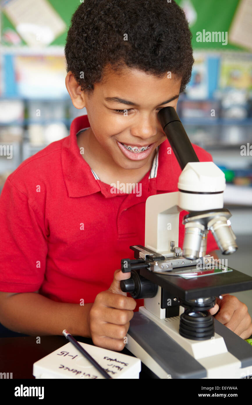 Boy in science class with microscope Stock Photo - Alamy