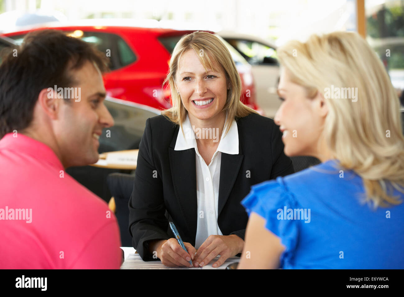 Woman working in car showroom Stock Photo - Alamy
