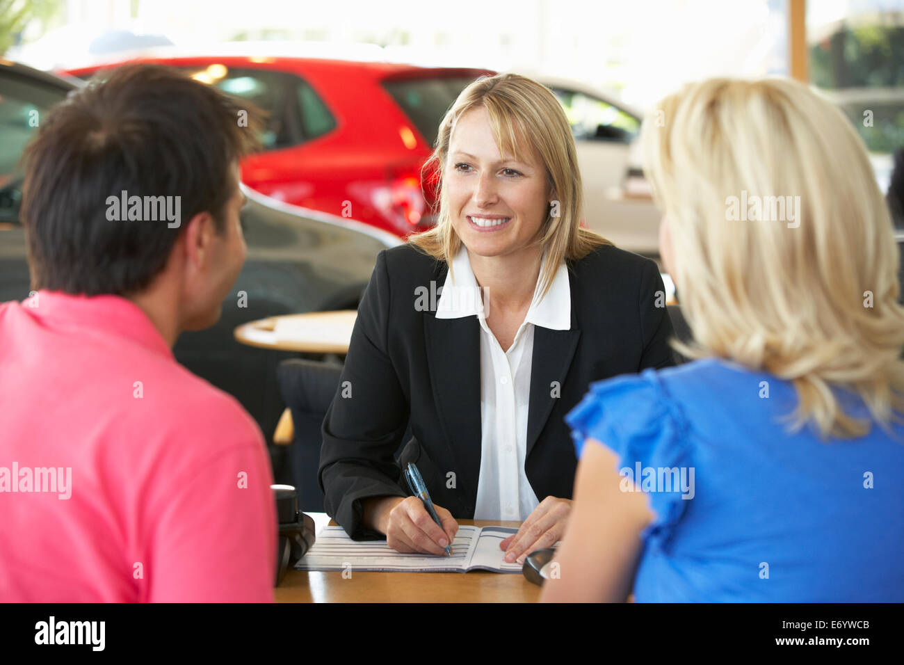 Woman working in car showroom Stock Photo - Alamy