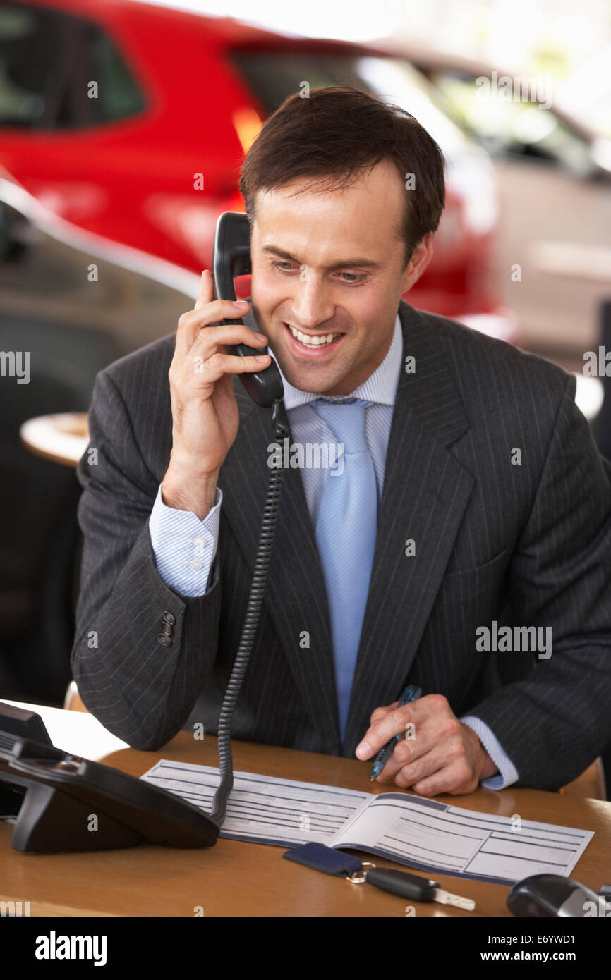 Man working in car showroom Stock Photo - Alamy