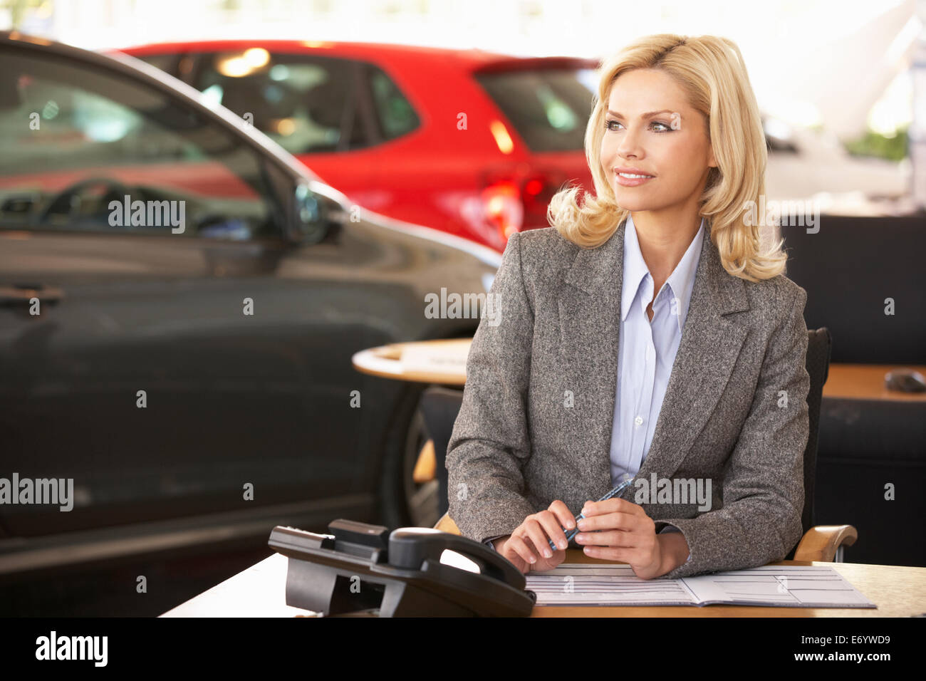 Woman working in car showroom Stock Photo - Alamy