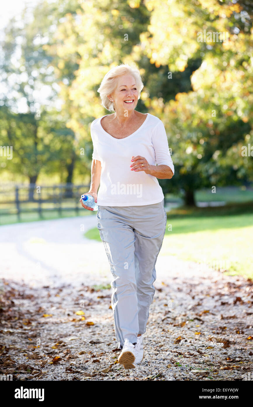 Senior woman running in park Stock Photo - Alamy