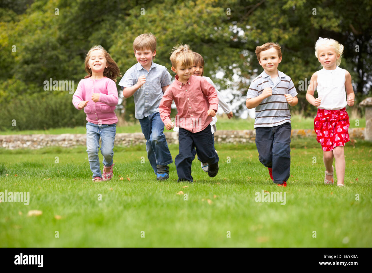 Small group young children running in park Stock Photo - Alamy
