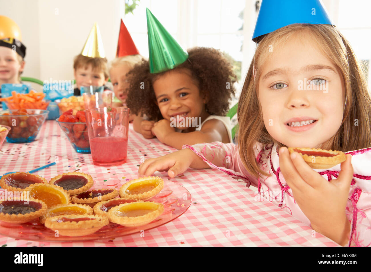 Young children eating jam tarts at birthday party Stock Photo - Alamy