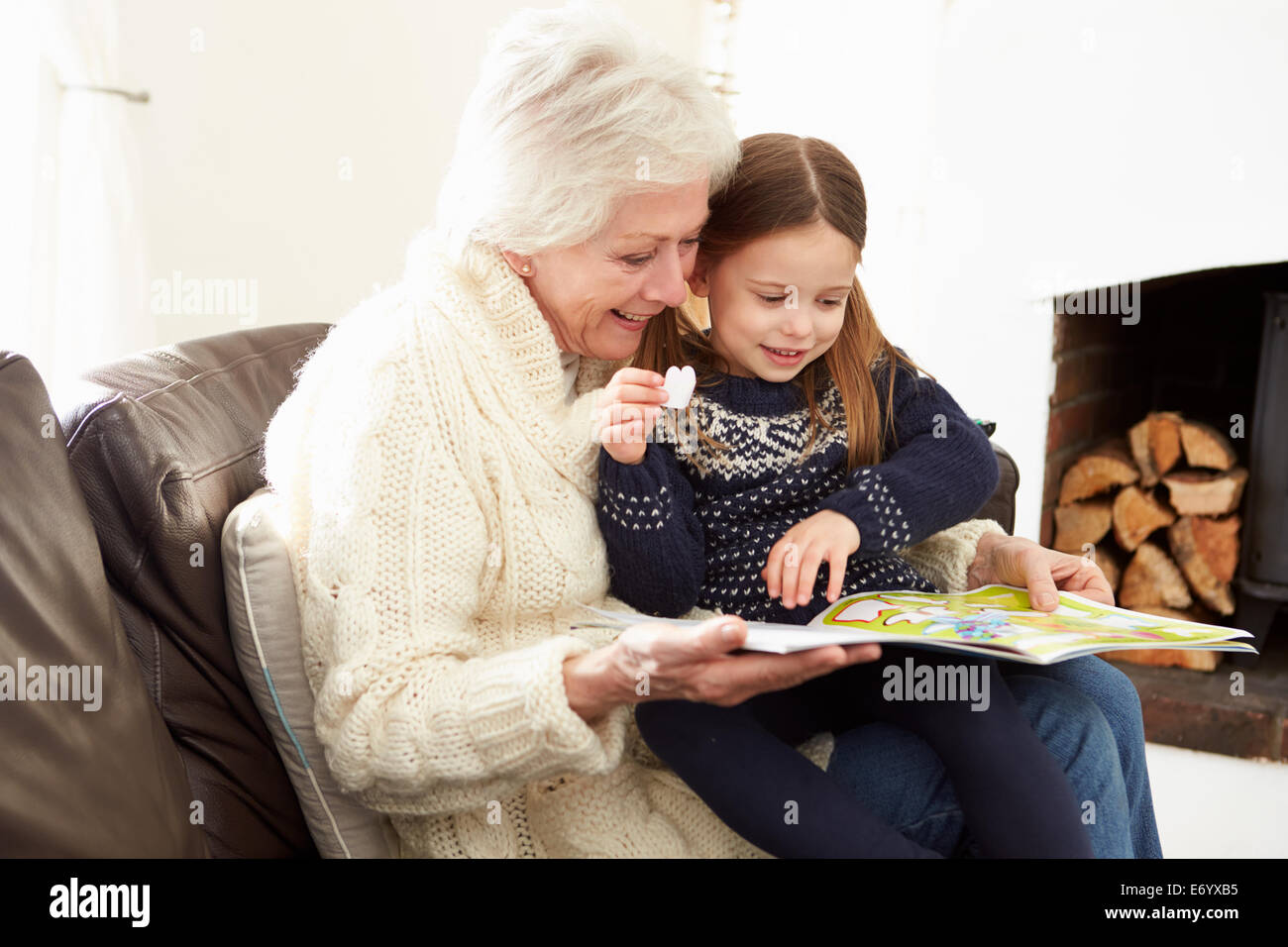 Grandmother And Granddaughter Reading Book At Home Together Stock Photo ...